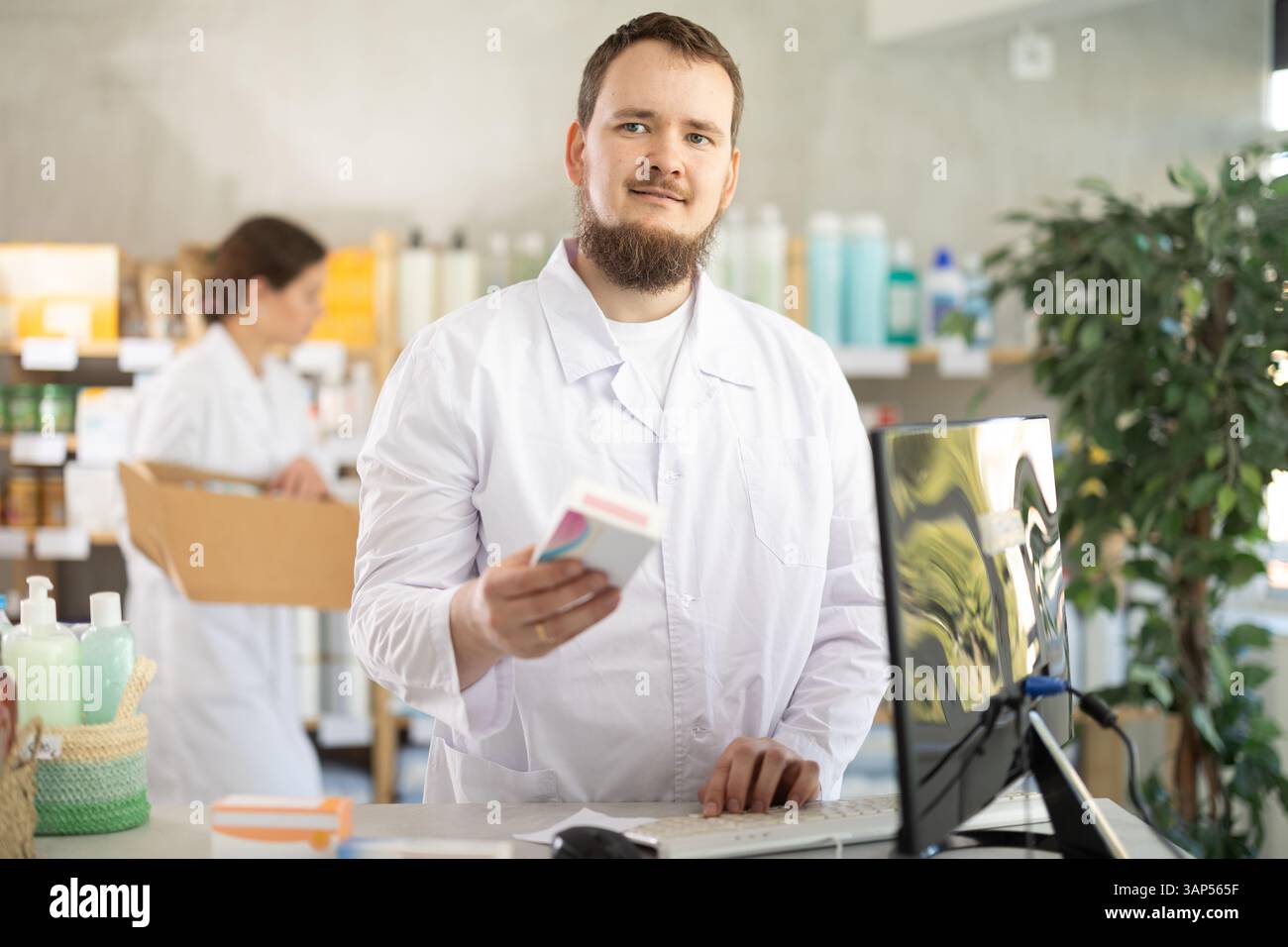 Male pharmacist standing behind counter in pharmacy Stock Photo - Alamy
