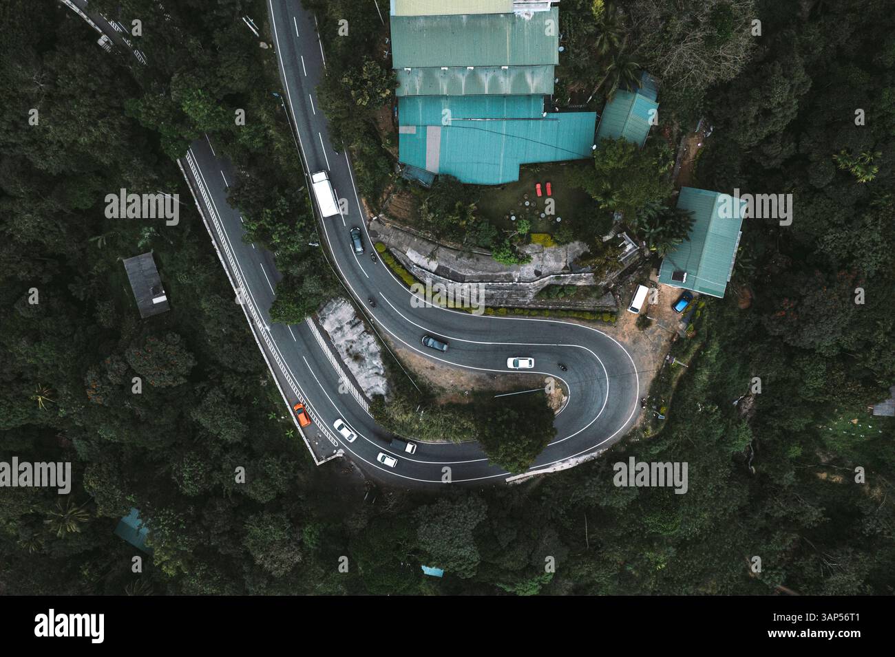 Aerial top down view of vehicles driving on winding mountain road in ...