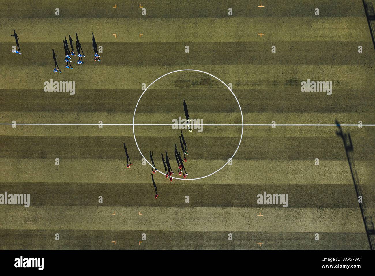 Aerial view of football teams entering the field in local stadium ...