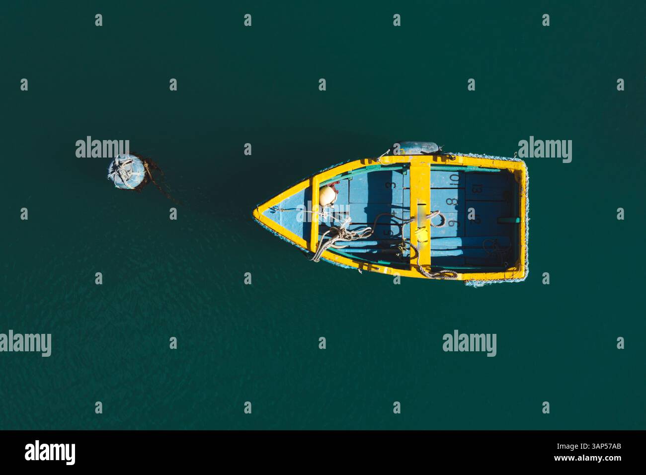Aerial top down view of tiny colourful wooden boat floating in ...
