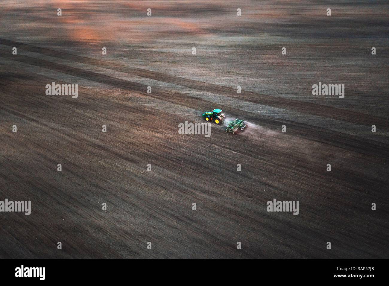 Aerial view of tractor working with harrow in agricultural farmland ...