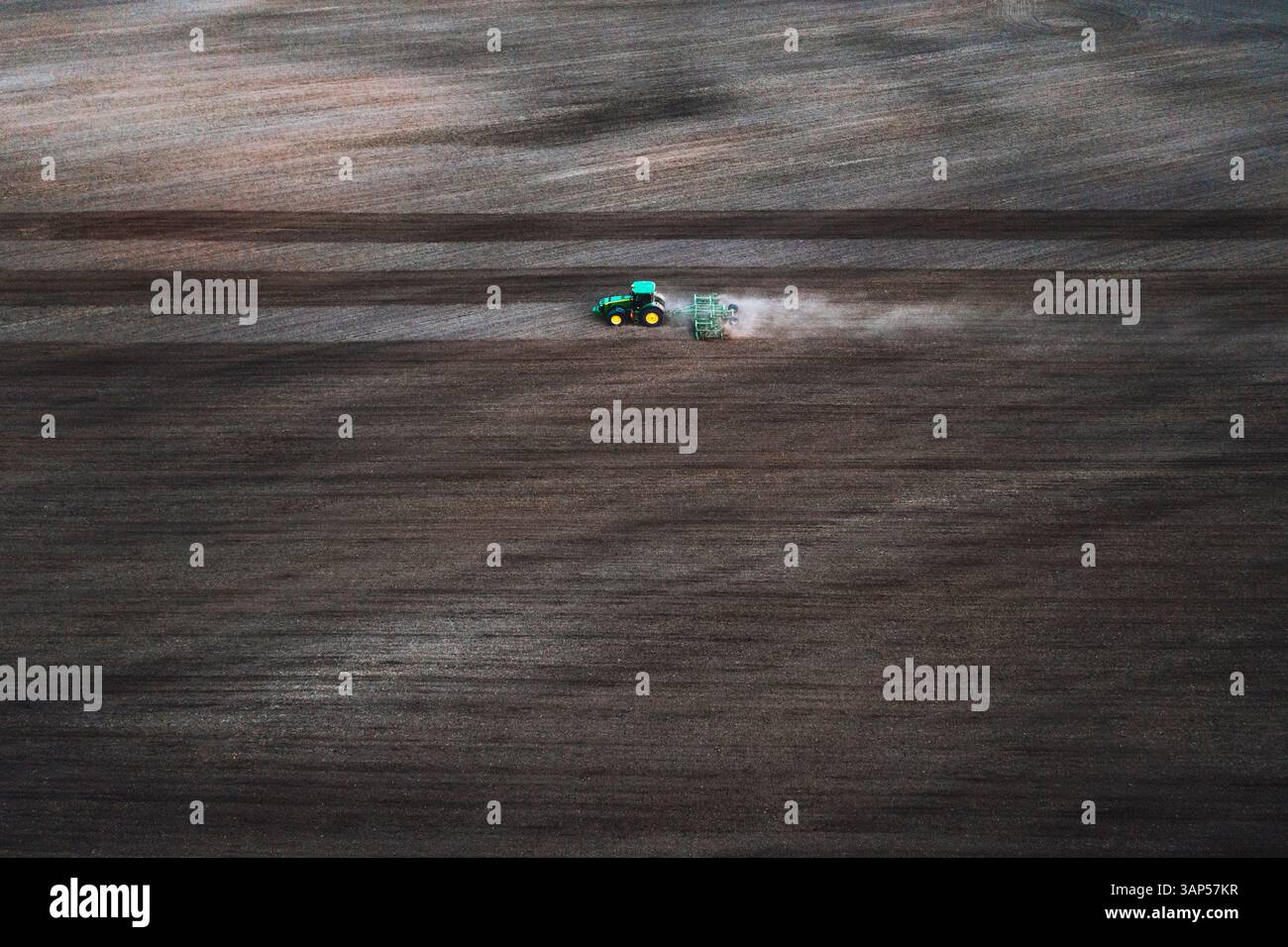 Aerial view of tractor working with harrow in agricultural farmland ...
