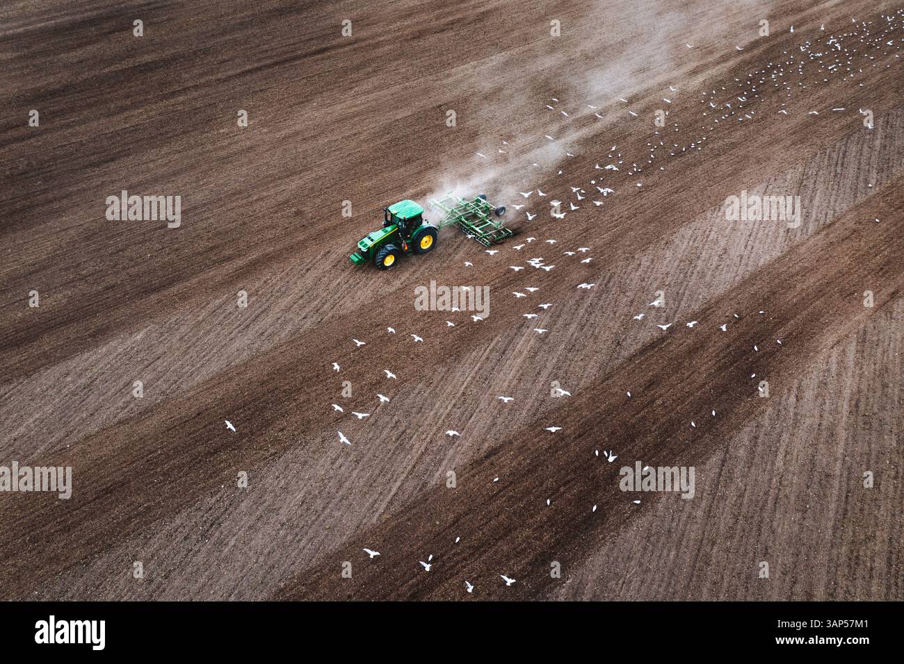 Aerial view of tractor working agricultural soil field land in ...