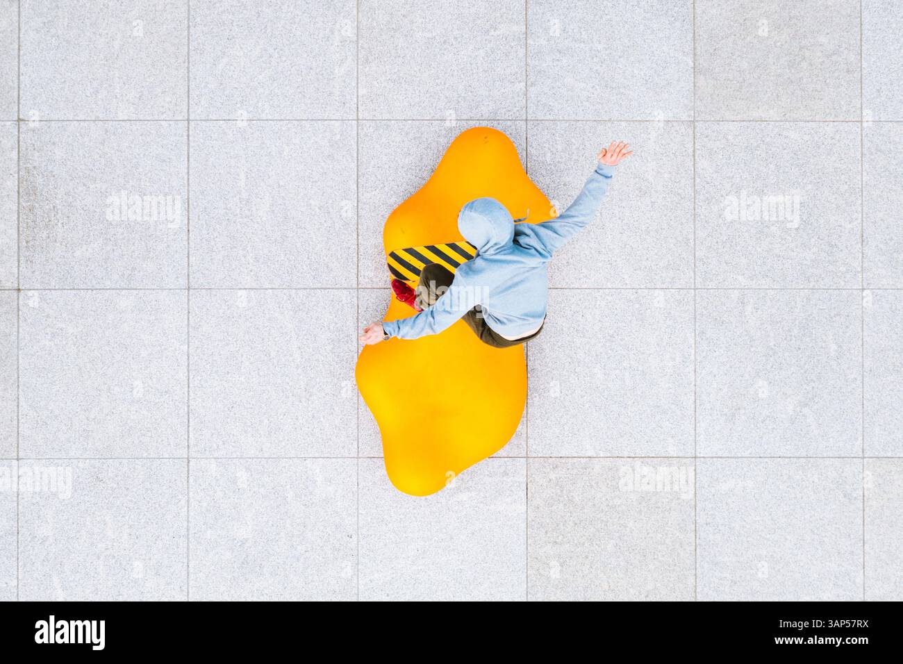 Aerial view of professional skateboarder jumping over the modern yellow ...