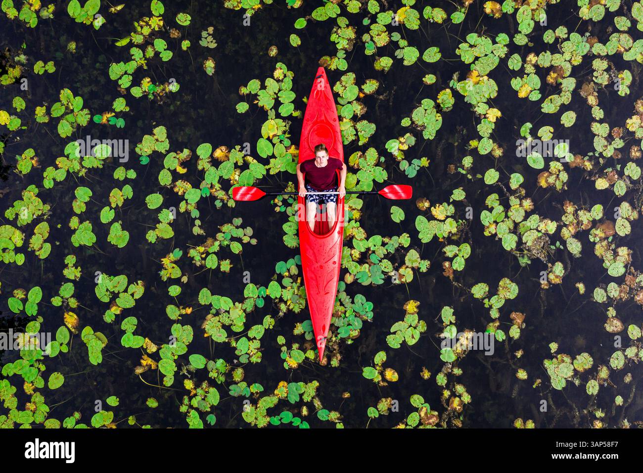 Aerial view of travel person paddling in wild river with red kayak ...