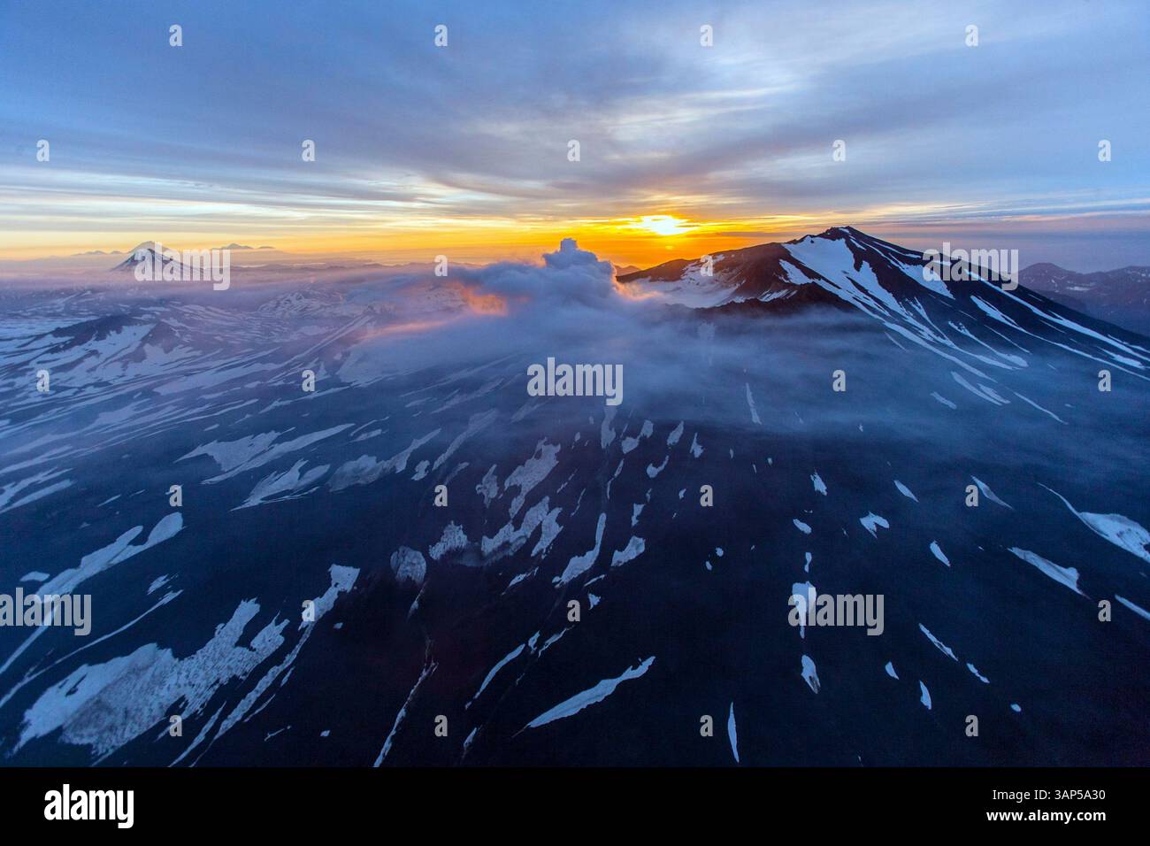 Aerial view of mutnovsky volcano at sunset surrounded by snow and ...