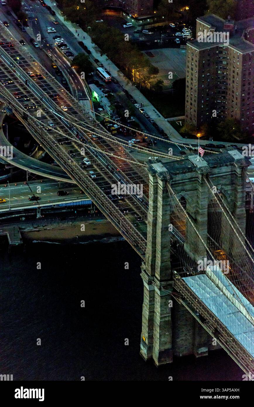 Aerial view of brooklyn bridge illuminated at night with bustling ...