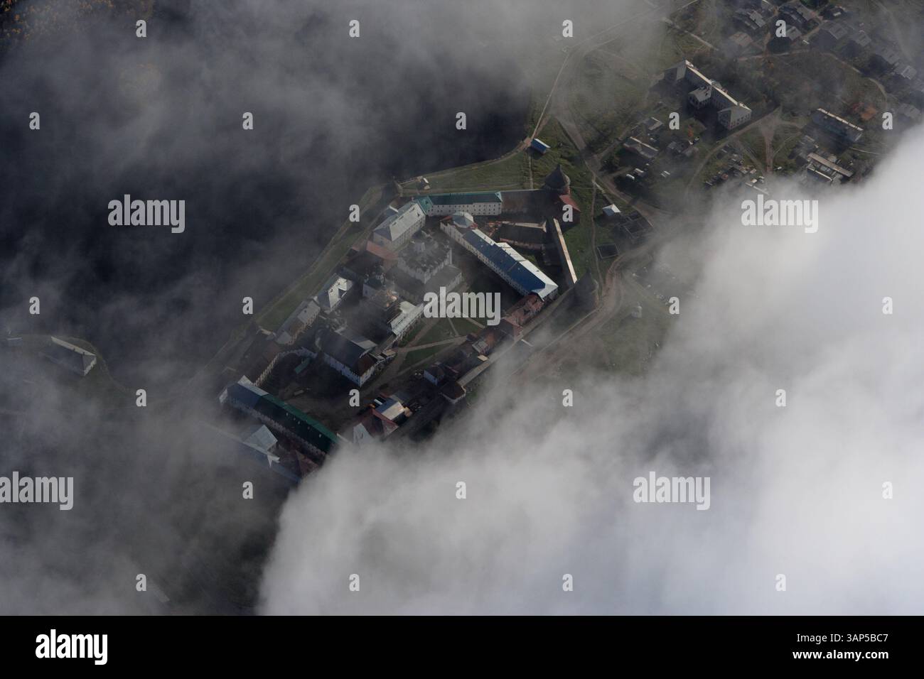 Aerial view of a mystical fortress surrounded by clouds and a tranquil ...