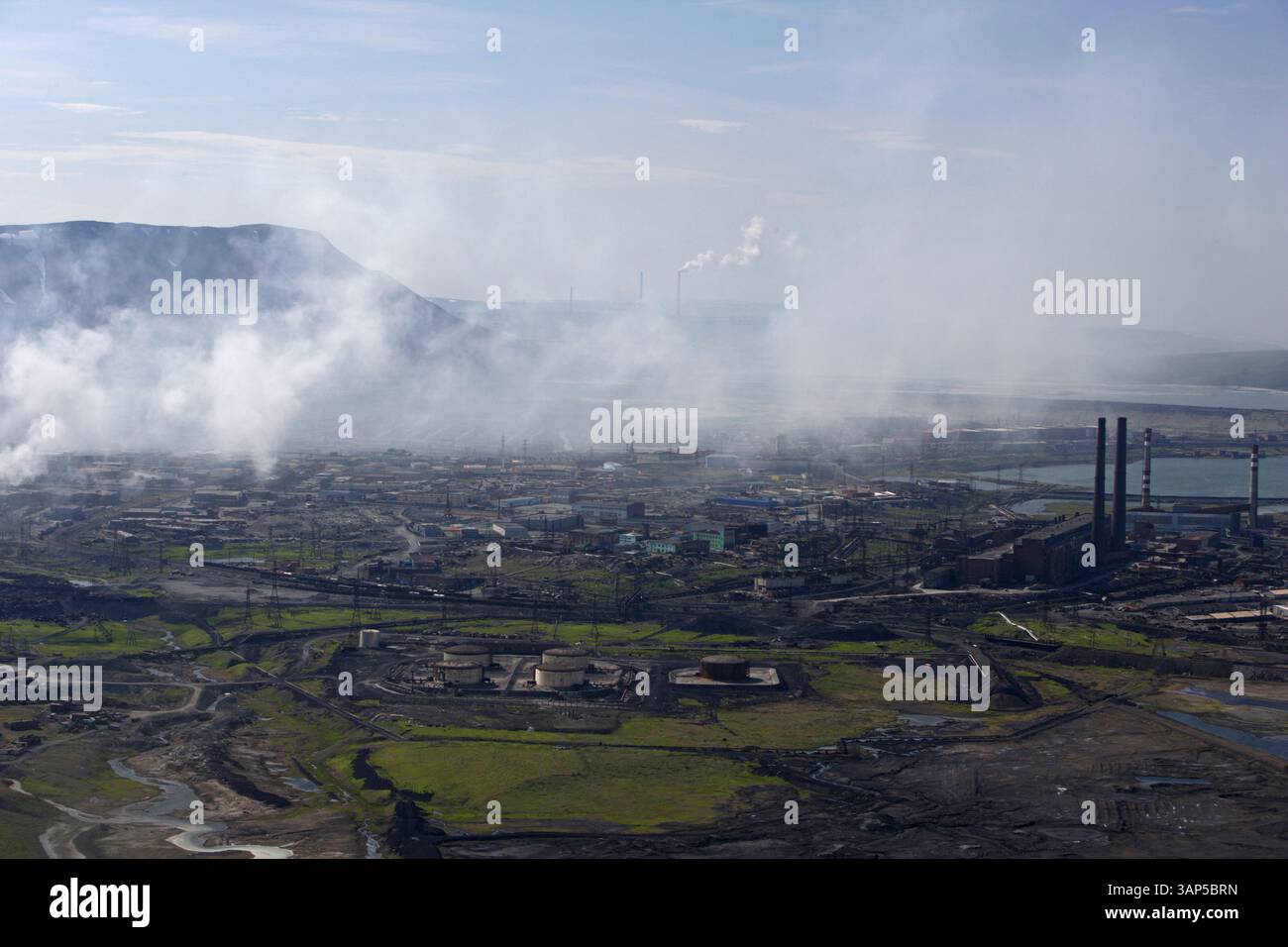 Aerial view of industrial factory with smokestacks amidst urban ...