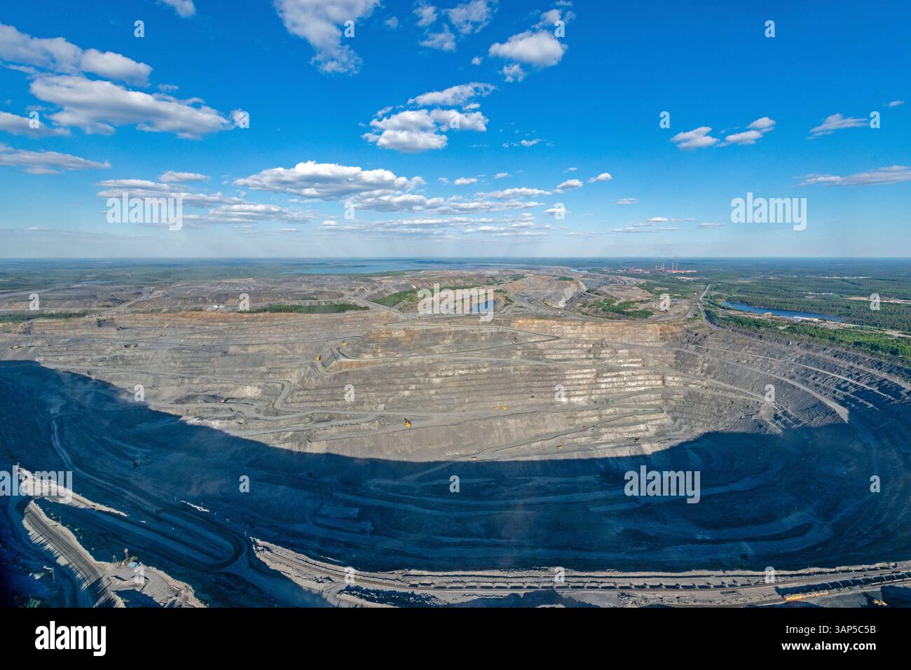 Aerial view of expansive open pit quarry under a beautiful blue sky ...