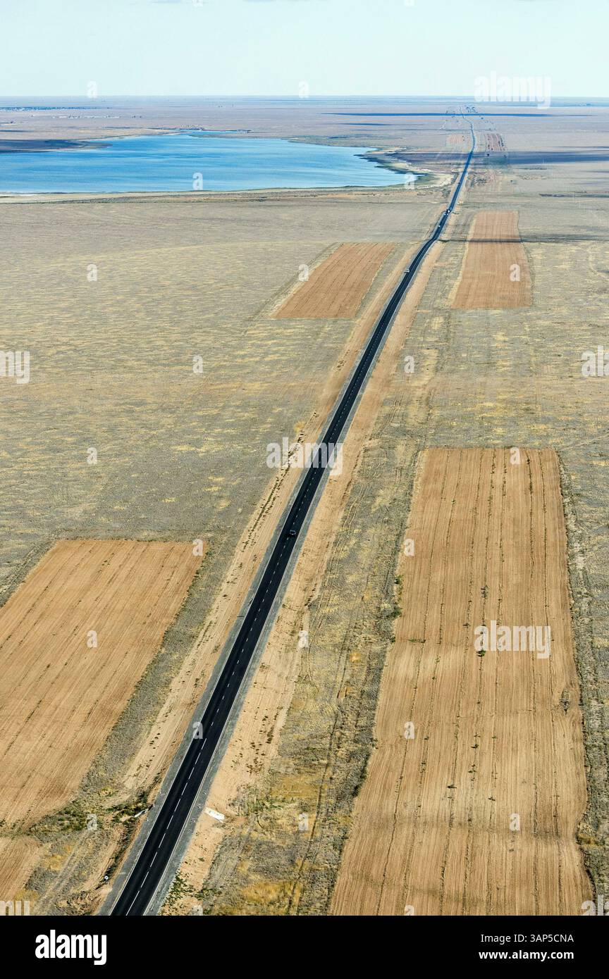 Aerial view of vast fields and a straight road under a beautiful sky, Kalmykia Republic, Russia ...