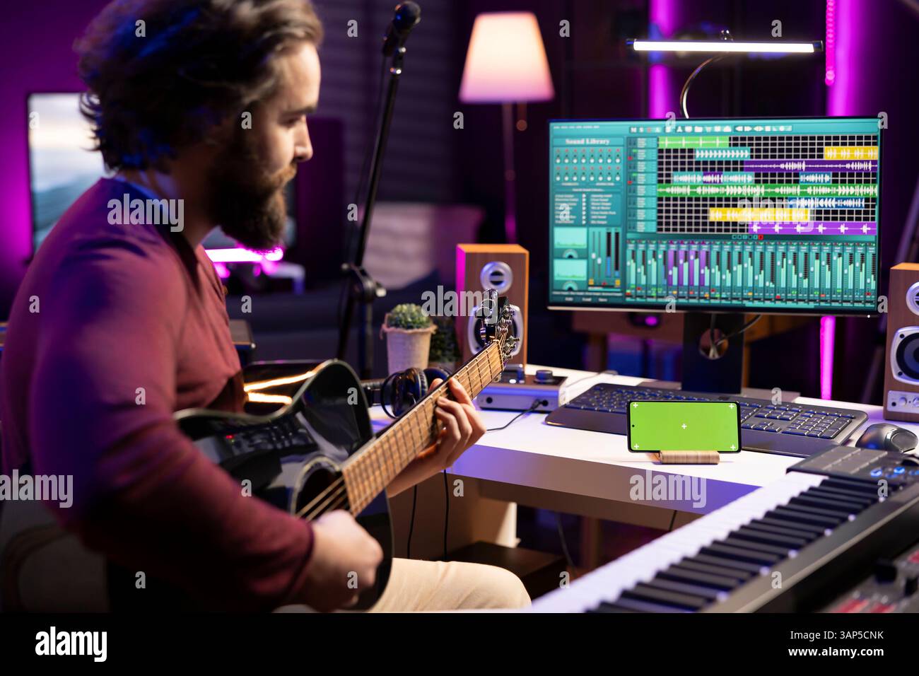 Young artist playing acoustic instrument accords in home studio with ...