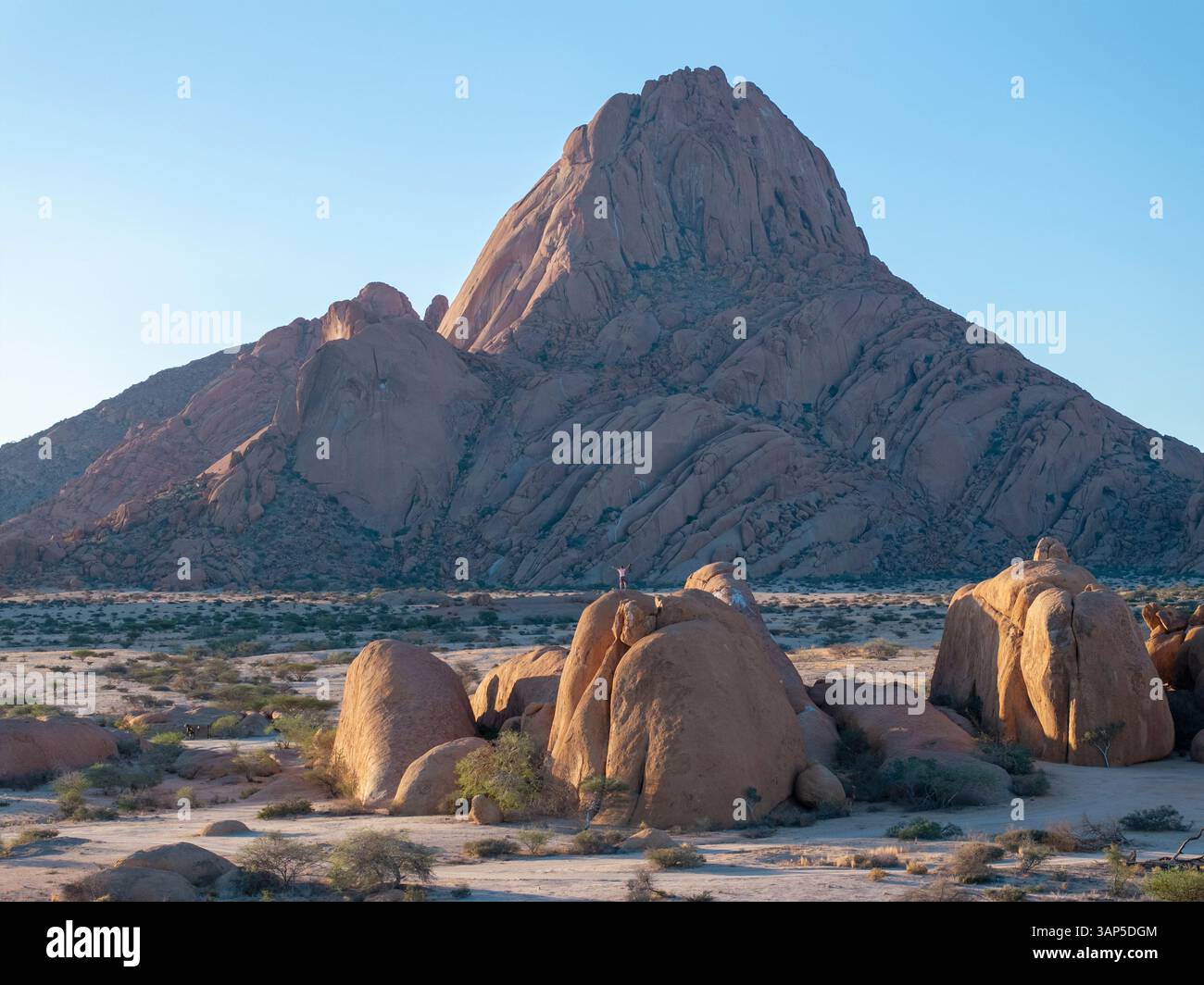 Aerial view of spizklopp rock formation with a man standing on the rock ...