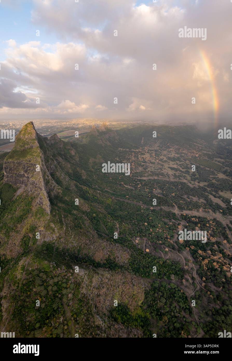 Aerial view of majestic mountains with a vibrant rainbow and dramatic ...