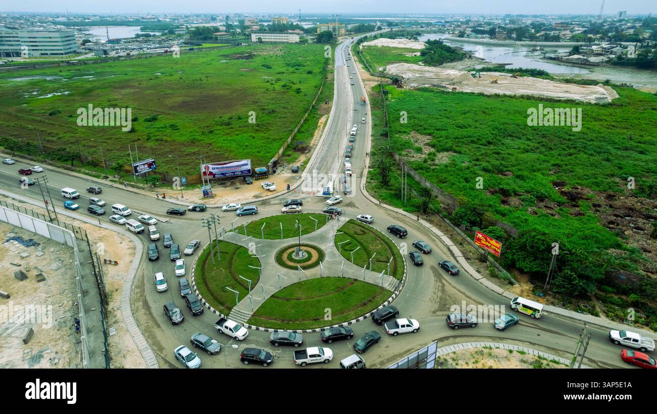 Aerial view of a busy roundabout with cars and greenery surrounded by modern buildings, Port ...