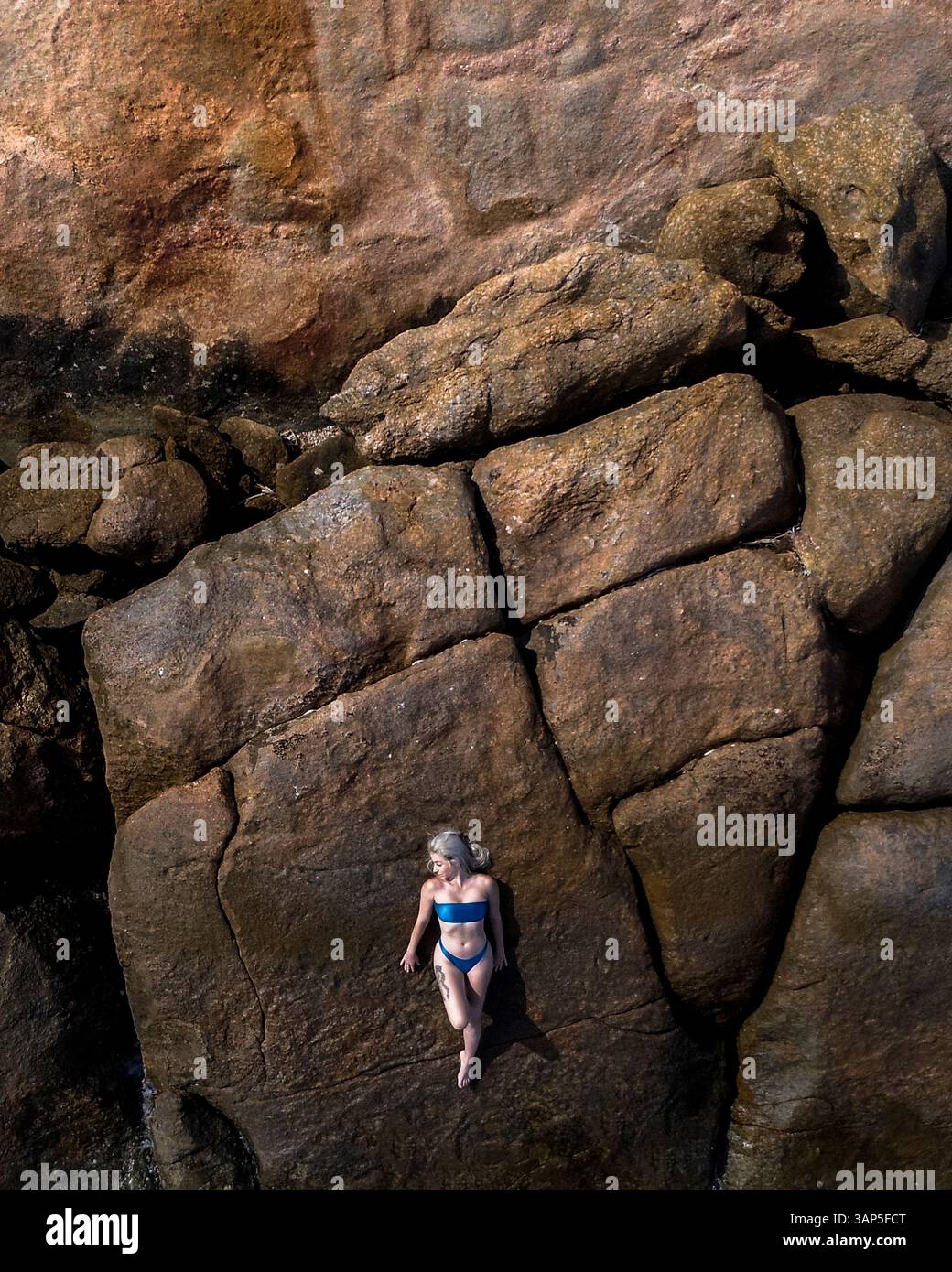 Aerial view of a woman relaxing on the rocks Duke of Orleans Bay ...