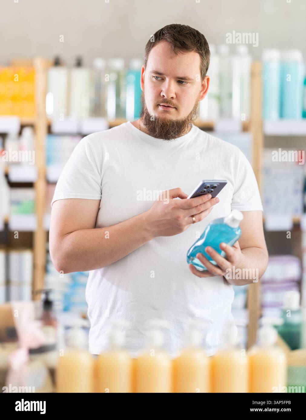 Man in summer clothes scans code on medicinal mouthwash to check ...