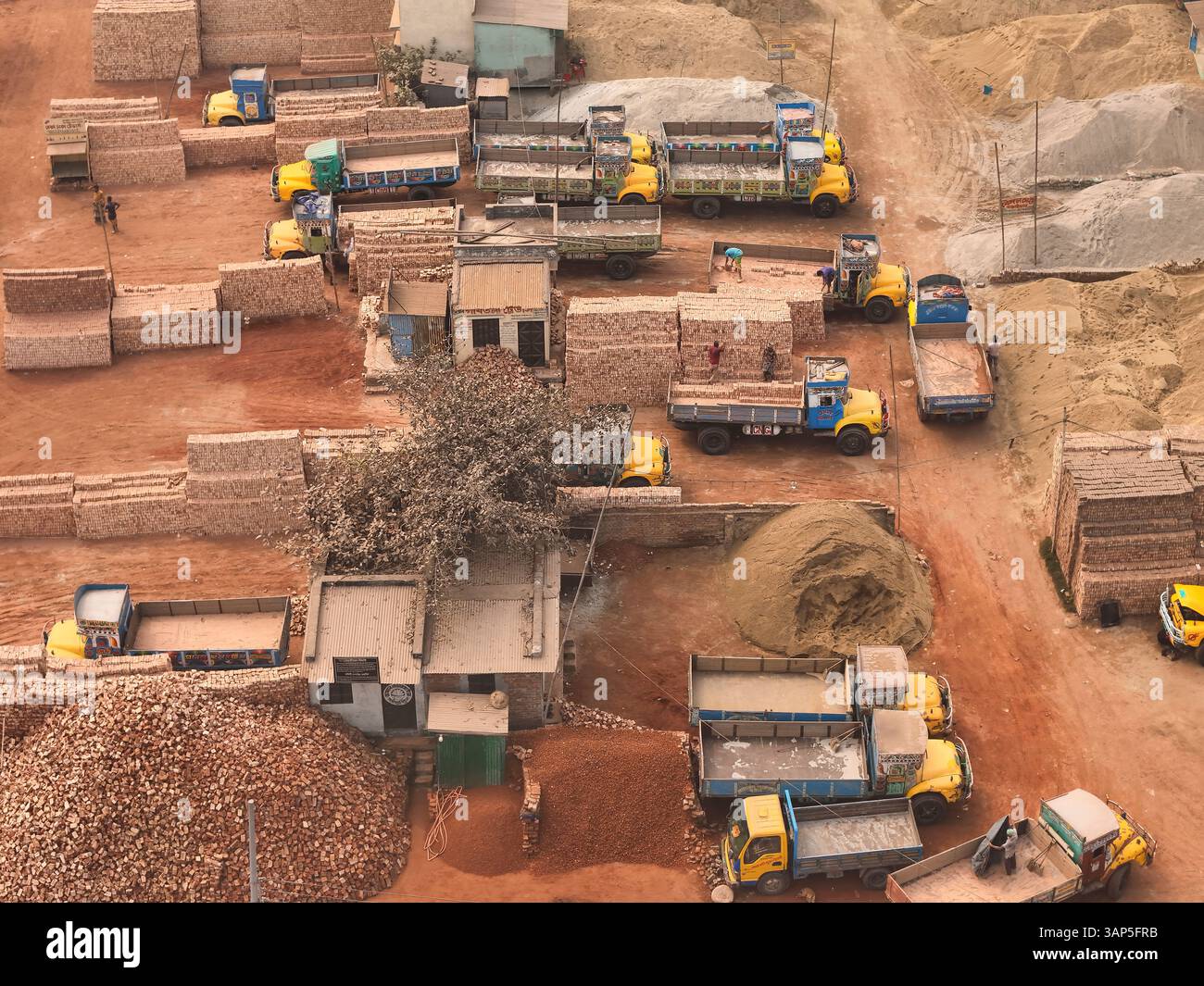 Aerial view of a brick factory with yellow trucks and heavy equipment ...