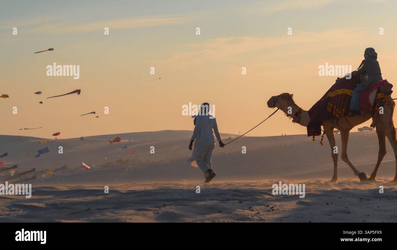 Doha, Qatar, February 24, 2025: A group of people riding camels through ...