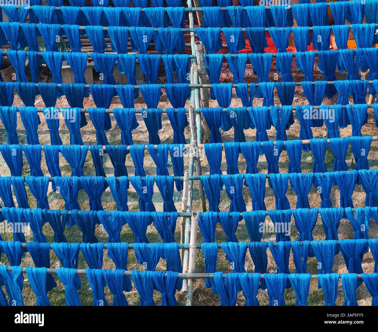 Aerial view of vibrant lines of colorful fabrics in a dying factory ...