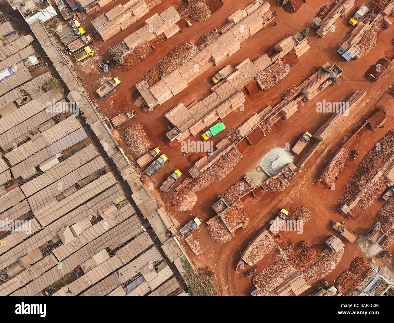 Aerial view of a bustling cattle market and brick factory with trucks ...