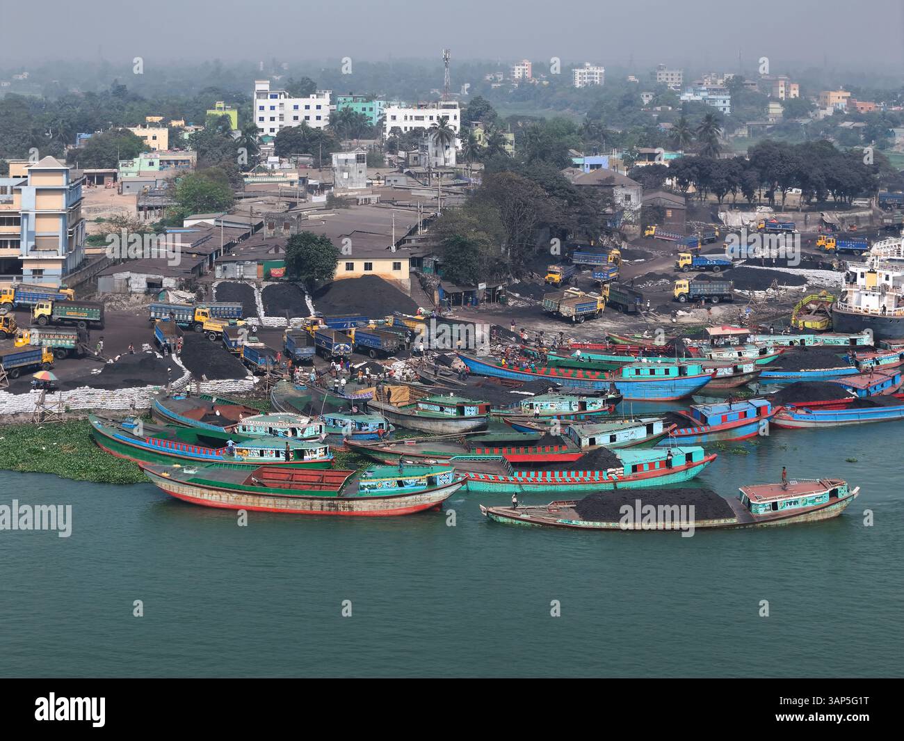 Aerial view of busy dock with boats on the river amidst an industrial cityscape, Dhaka, Dhaka ...