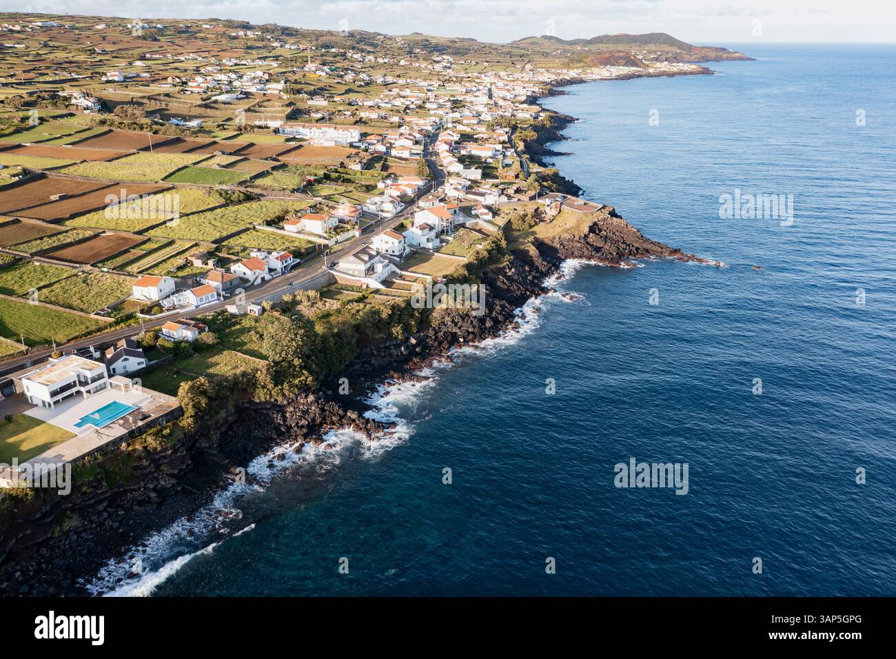 Aerial view of rural patchwork fields and a picturesque coastal village ...