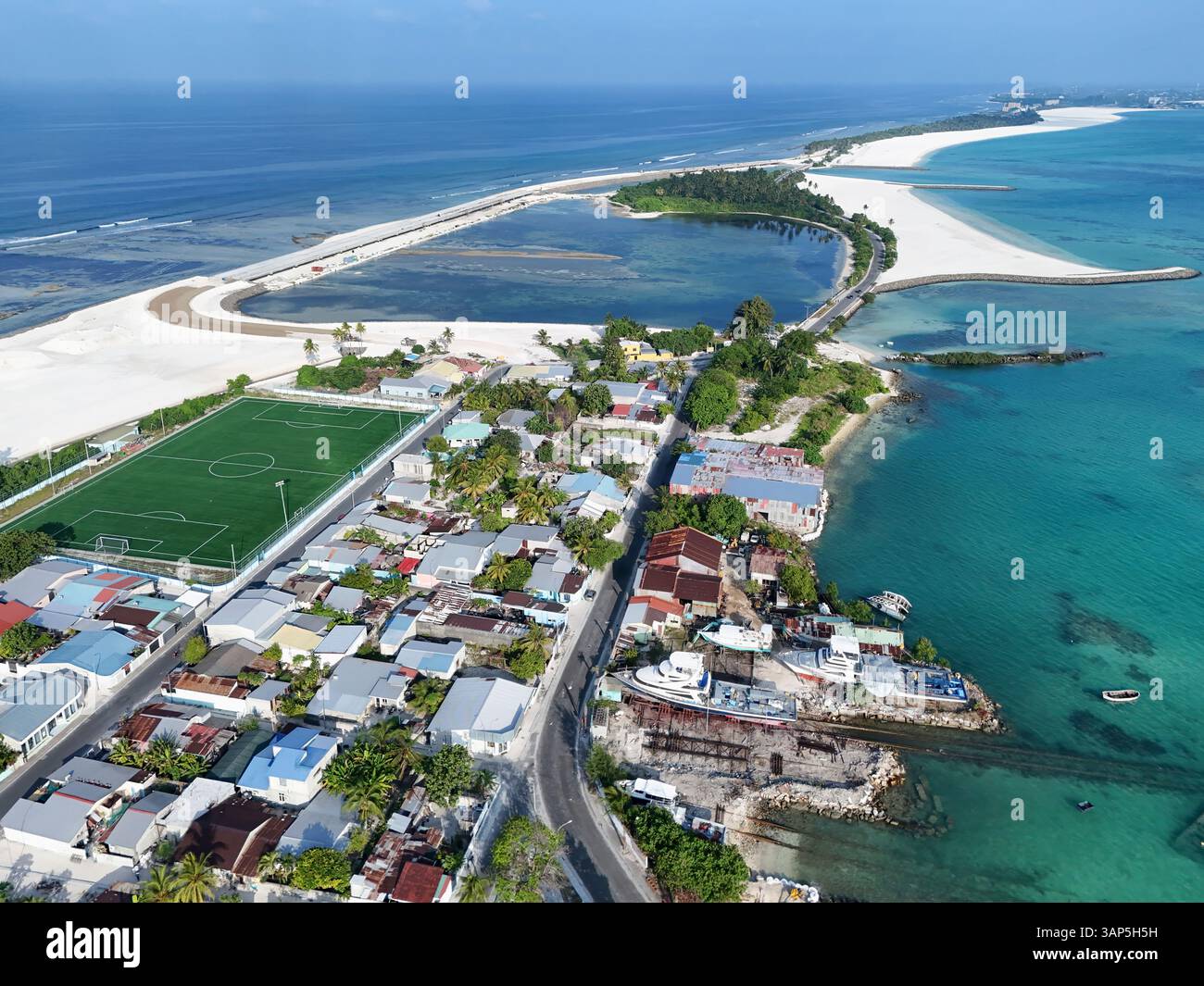Aerial view of artificial reclamation with palm trees and houses along ...