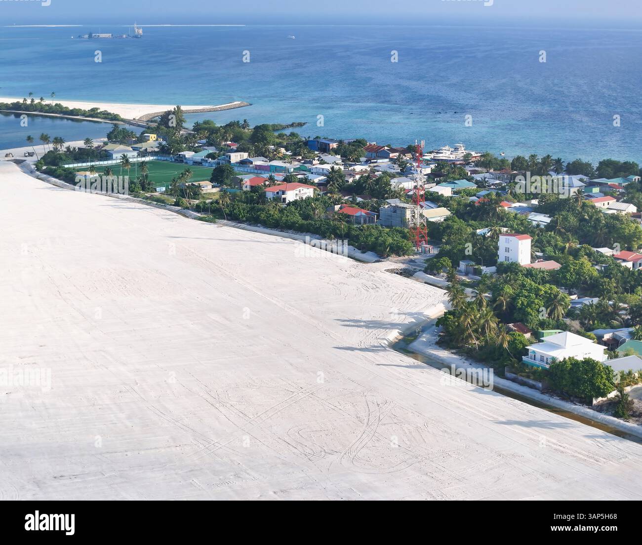 Aerial view of the reclamation area with houses and palm trees along ...