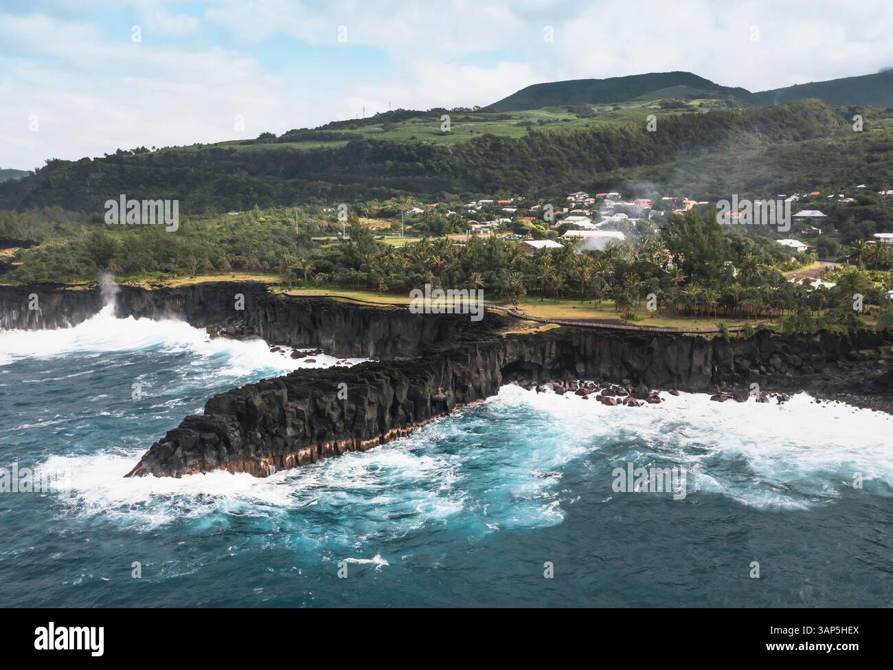 Aerial view of stormy waves crashing against rugged cliffs and a ...