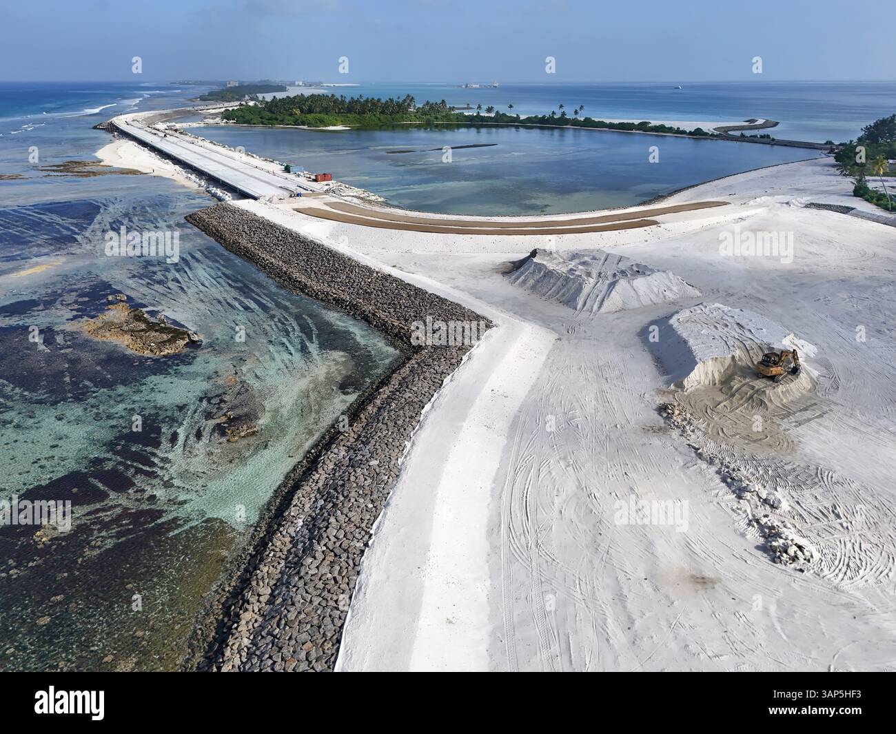 Aerial view of construction site with bridge, excavator, and coastline ...