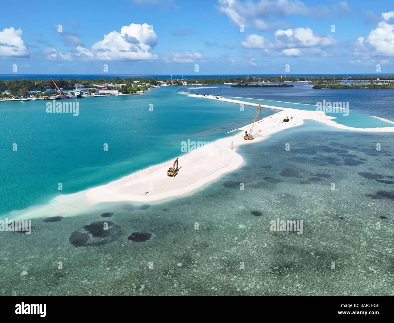 Aerial view of artificial island construction with excavator and crane ...