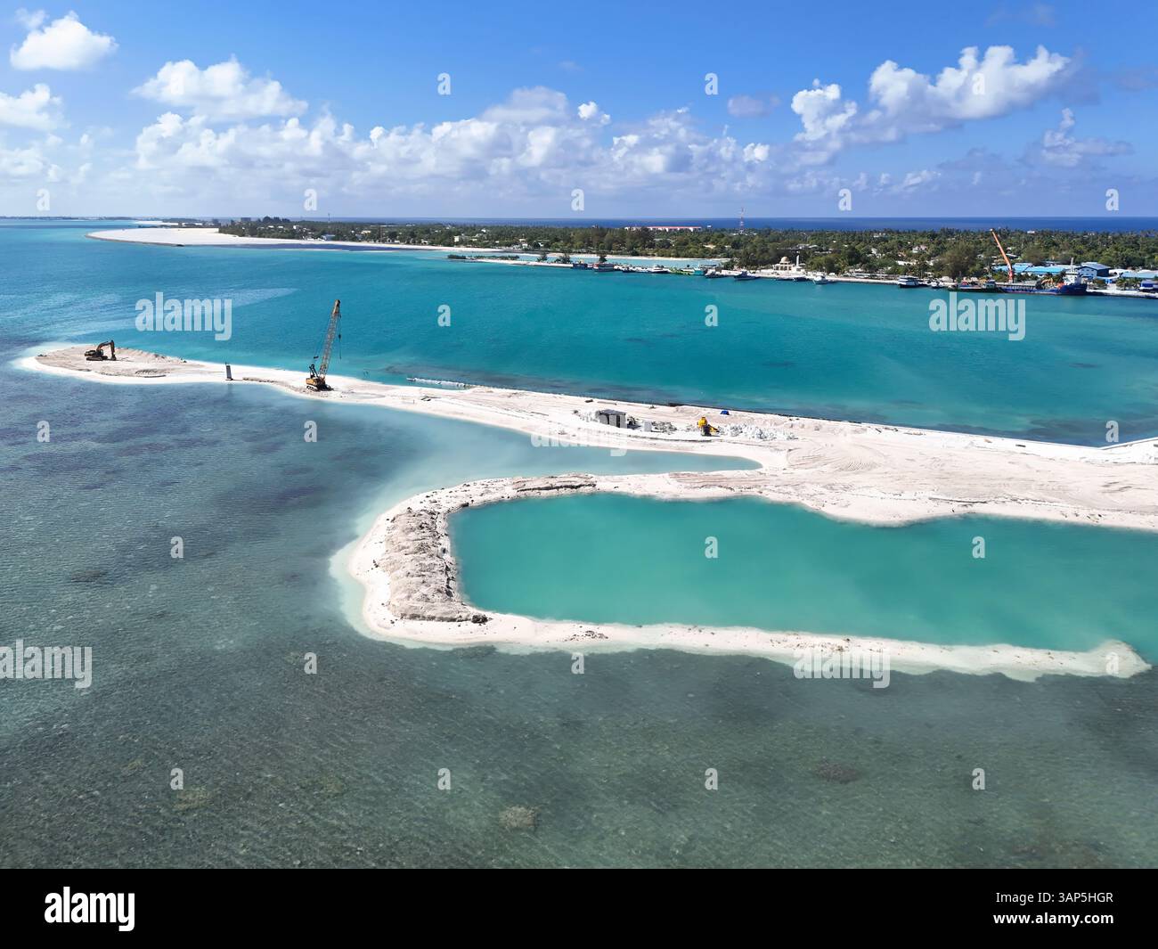 Aerial view of artificial island development with excavators and cranes ...