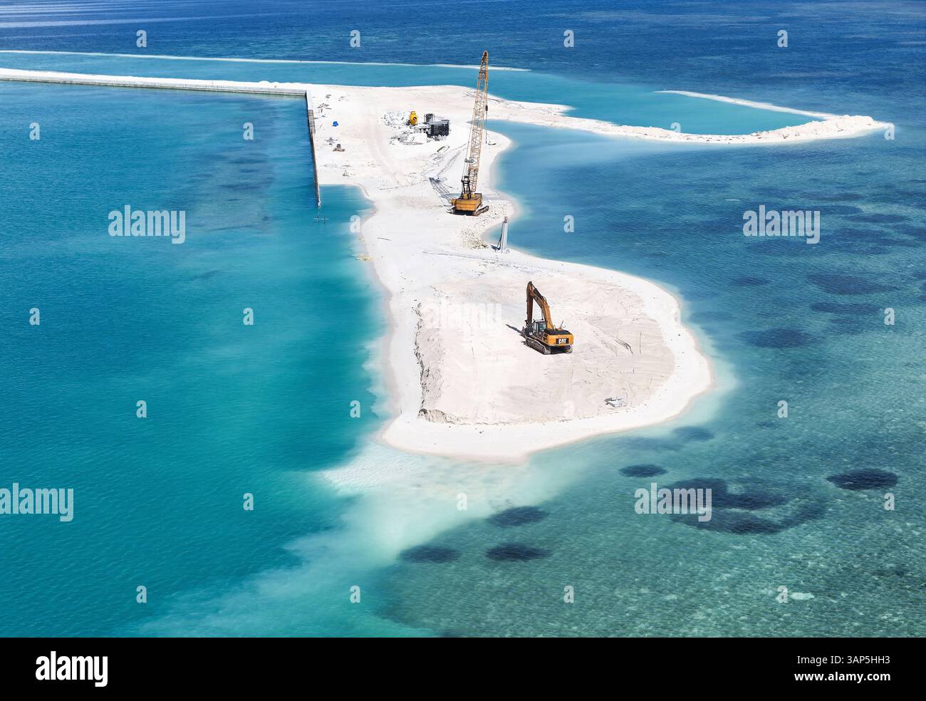 Aerial view of artificial island construction with excavator and crane ...