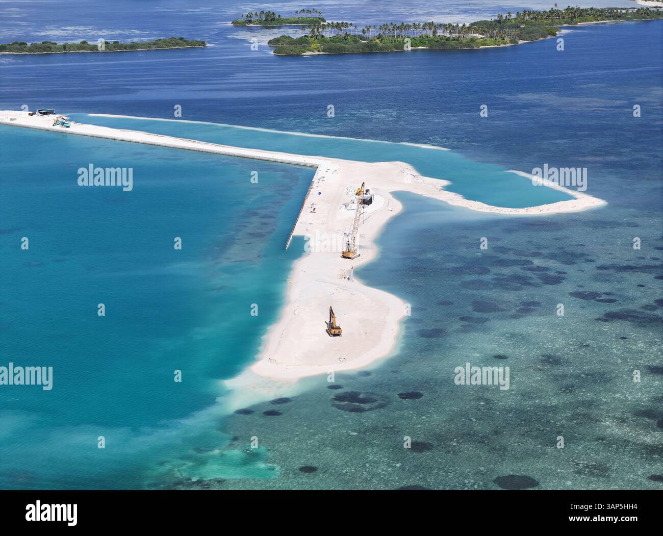 Aerial view of artificial island construction with excavator and crane ...