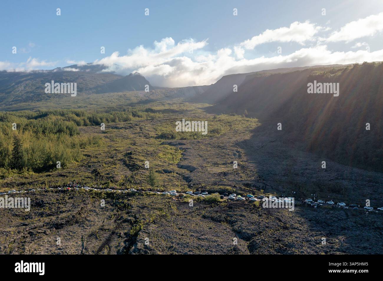 Aerial view of erupting Piton de la Fournaise volcano with cars and ...