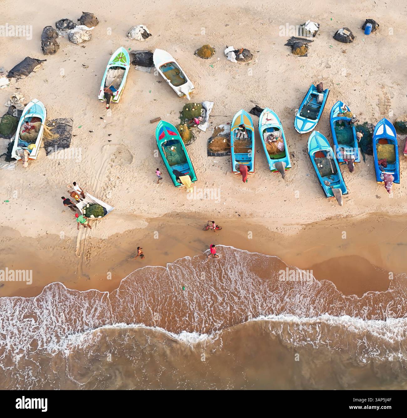 Aerial view of sandy beach with fishing boats and litter, Negombo, Sri ...