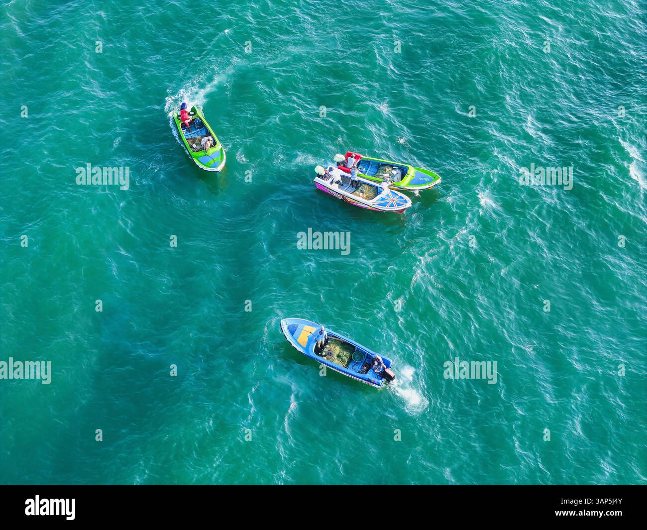 Aerial view of small fishing boats and fishermen on turquoise sea ...