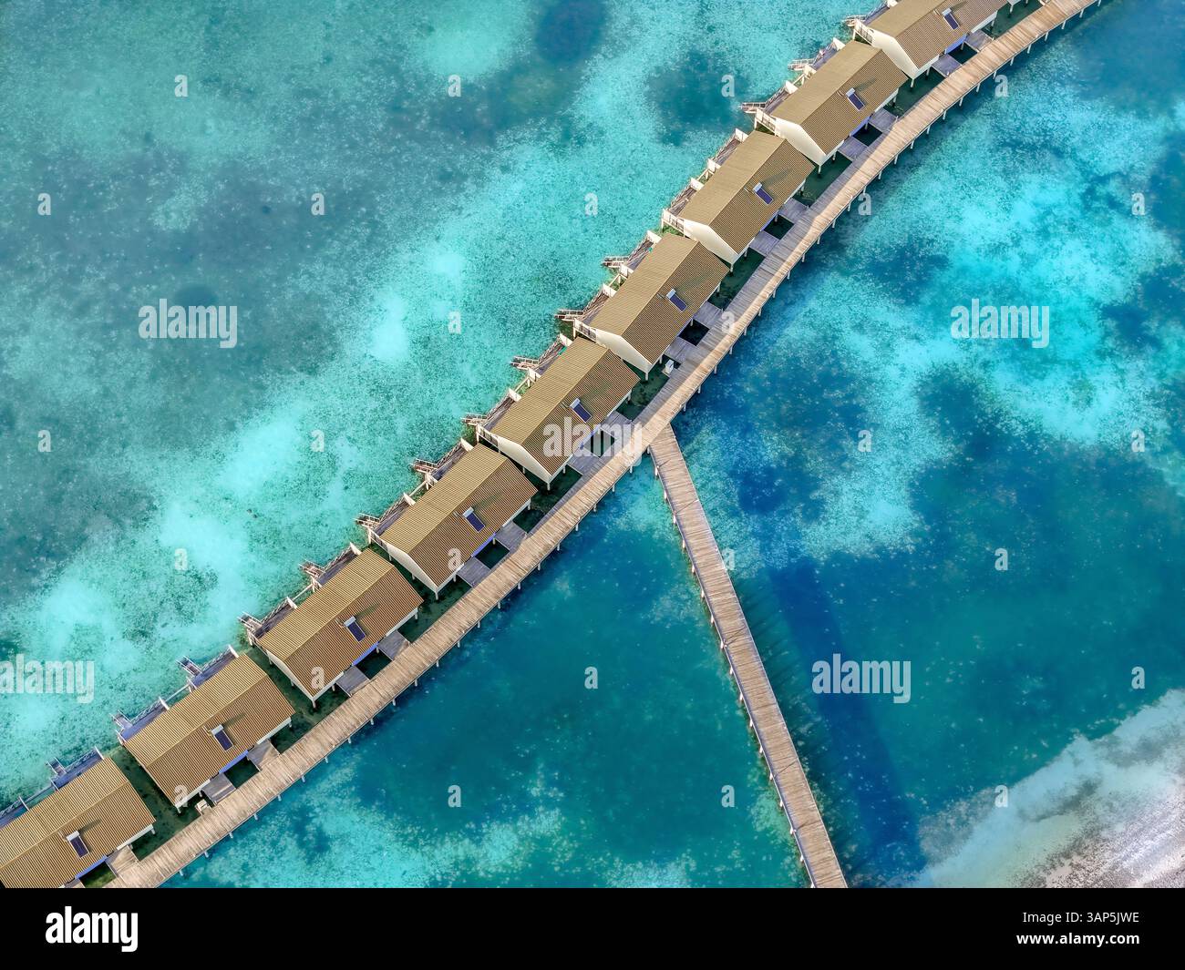 Aerial view of overwater bungalow in beautiful blue ocean, Addu Atoll ...