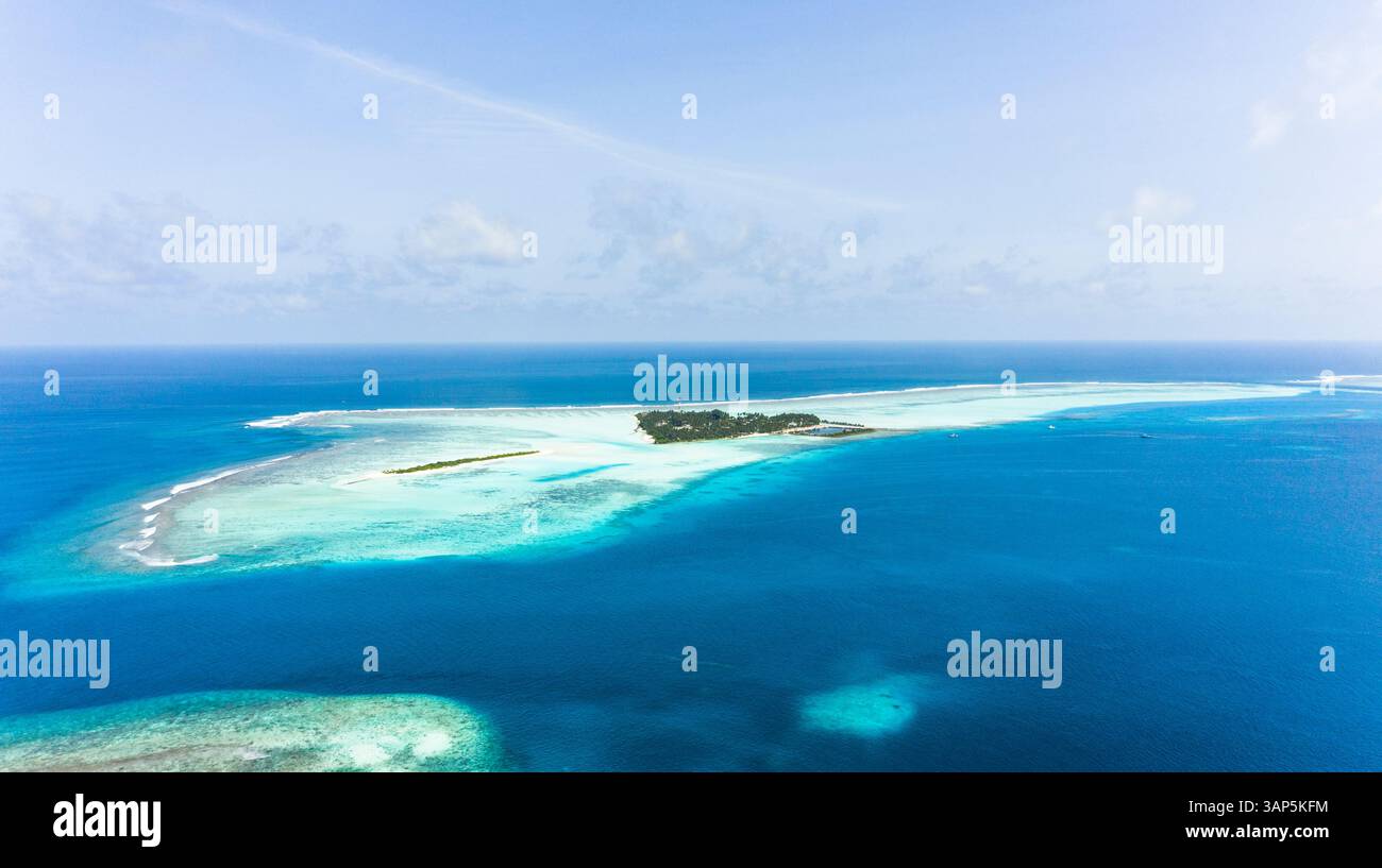 Aerial view of a luxurious resort with overwater villas and the local ...