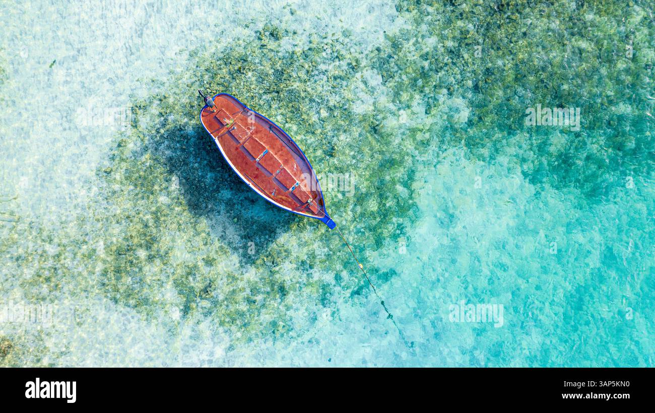 Aerial view of an anchored boat at the coast of the inhabited island ...