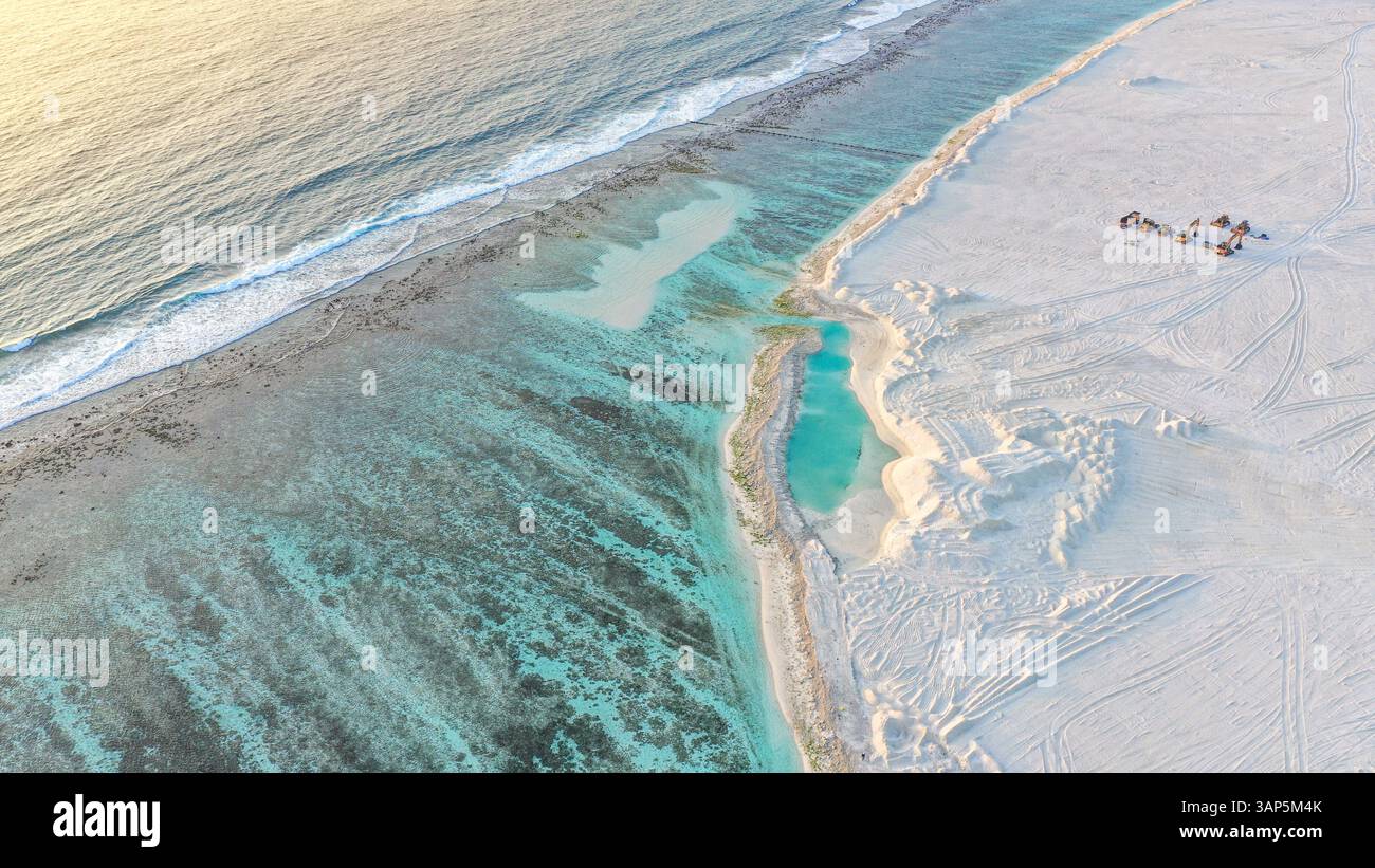 Aerial view of reclaimed land and calm waves breaking at the shore of ...