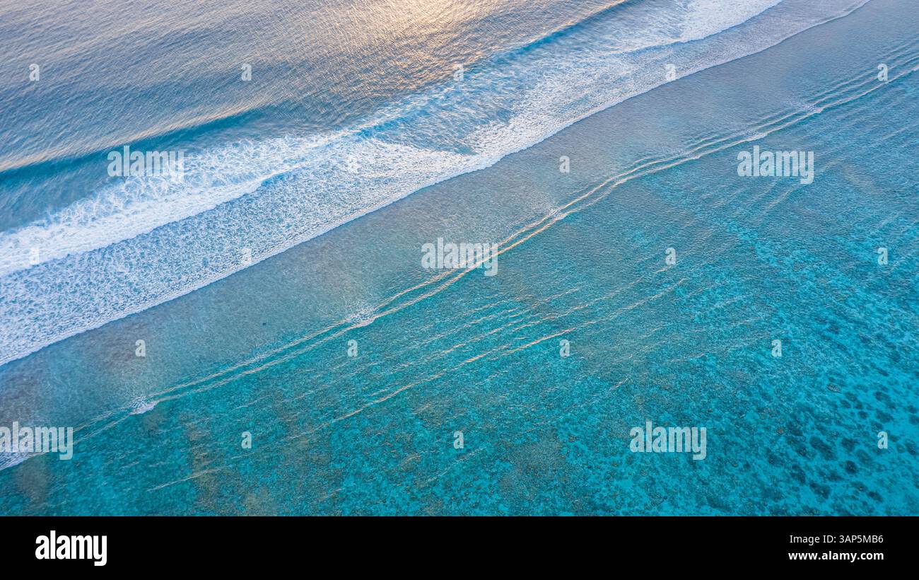 Aerial view of calm waves, breaking at the reef of the local ...