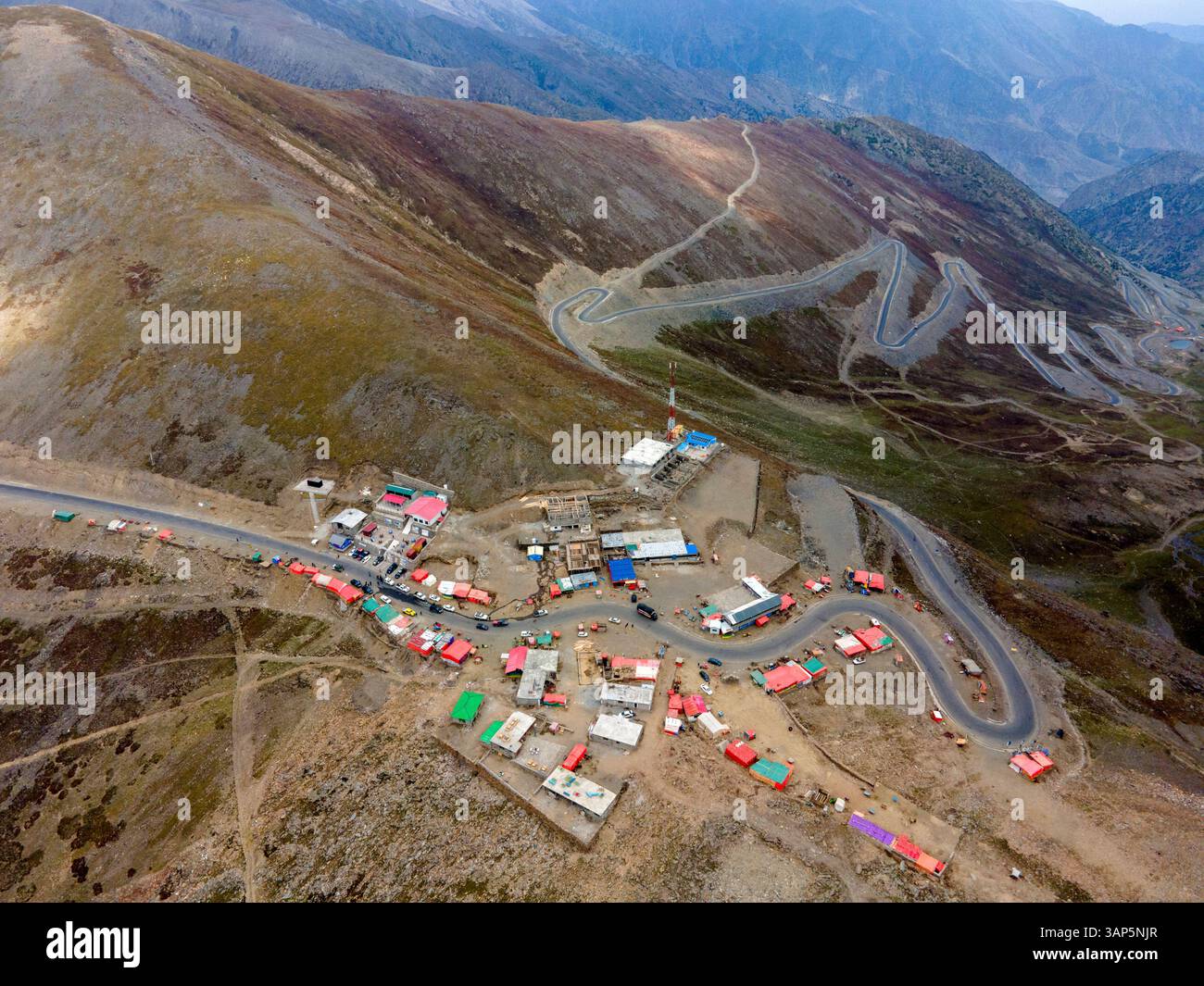 Aerial view of winding road through serene mountainous landscape with ...