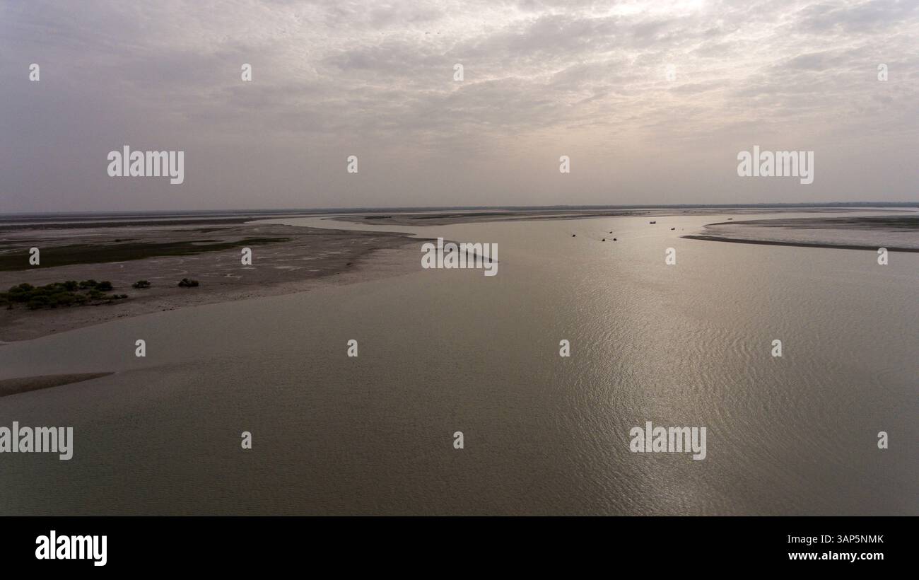 Aerial view of serene mangroves along a calm river and coastline, Keti ...