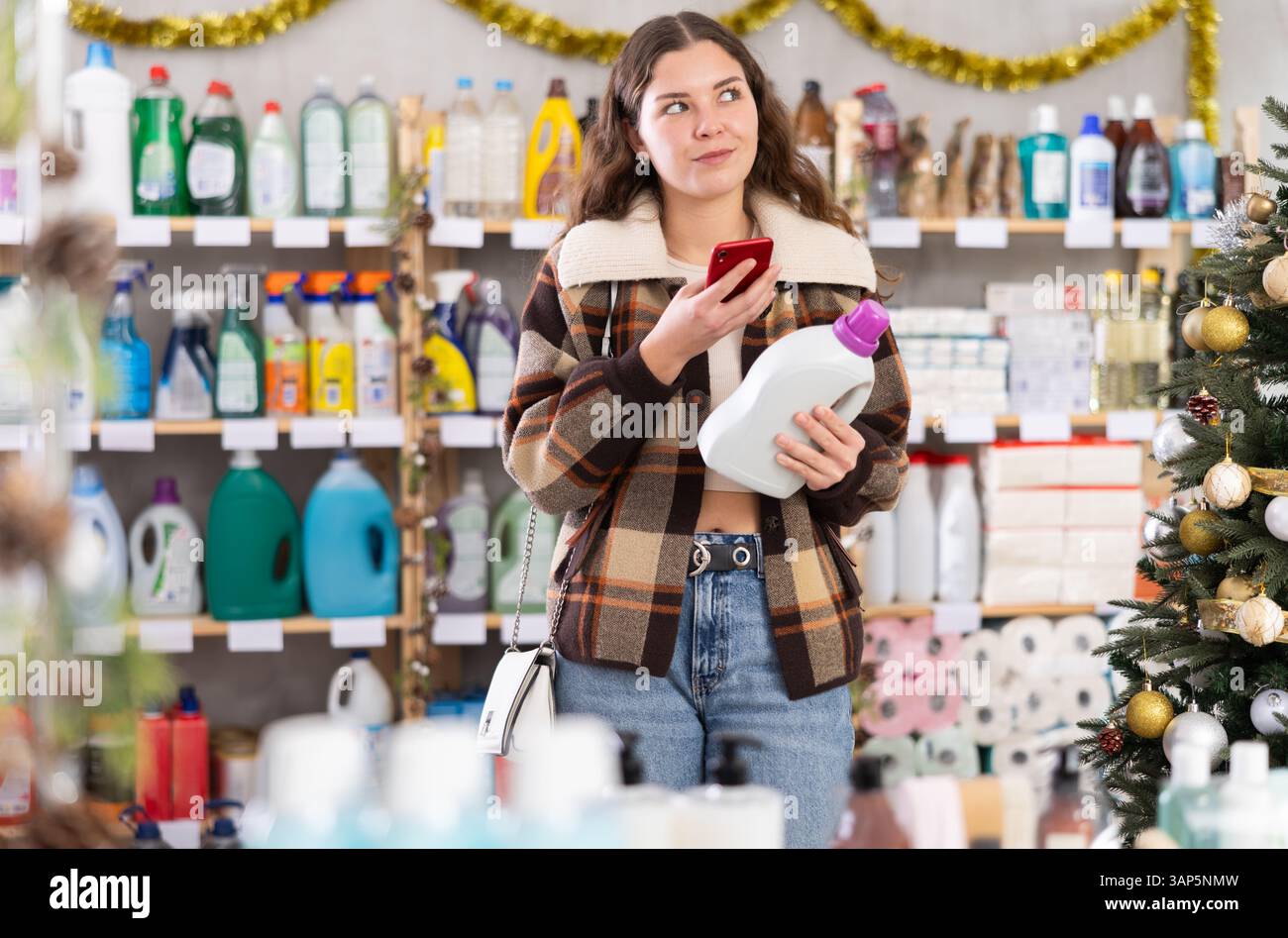 Young woman scanning qr code for detergent Stock Photo - Alamy