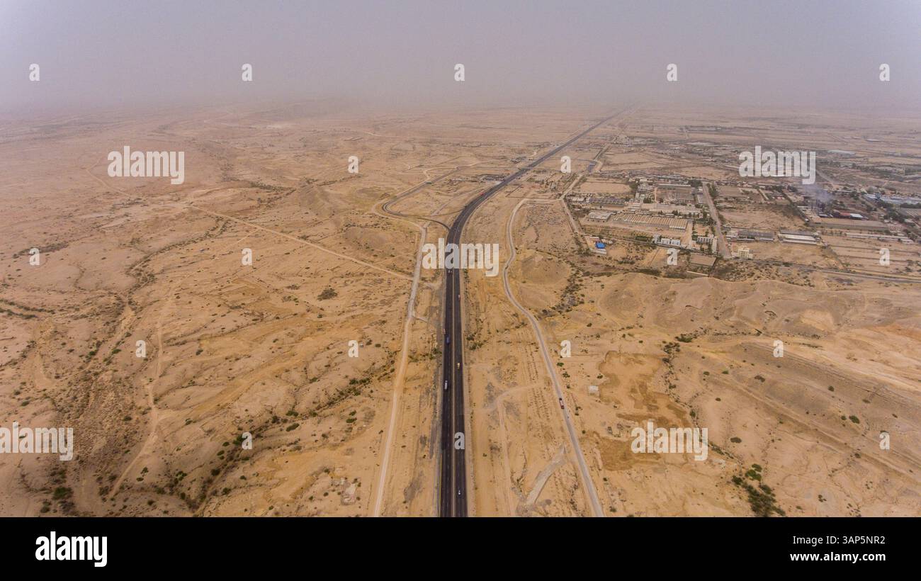 Aerial view of the sandy desert landscape with a highway stretching ...