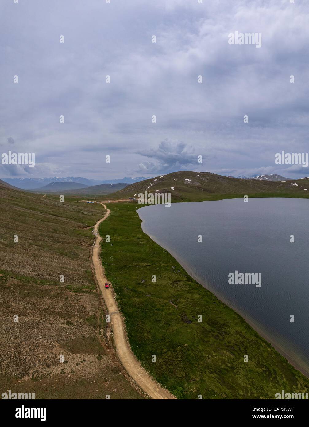 Aerial view of deosai plains with a serene lake and majestic mountains ...