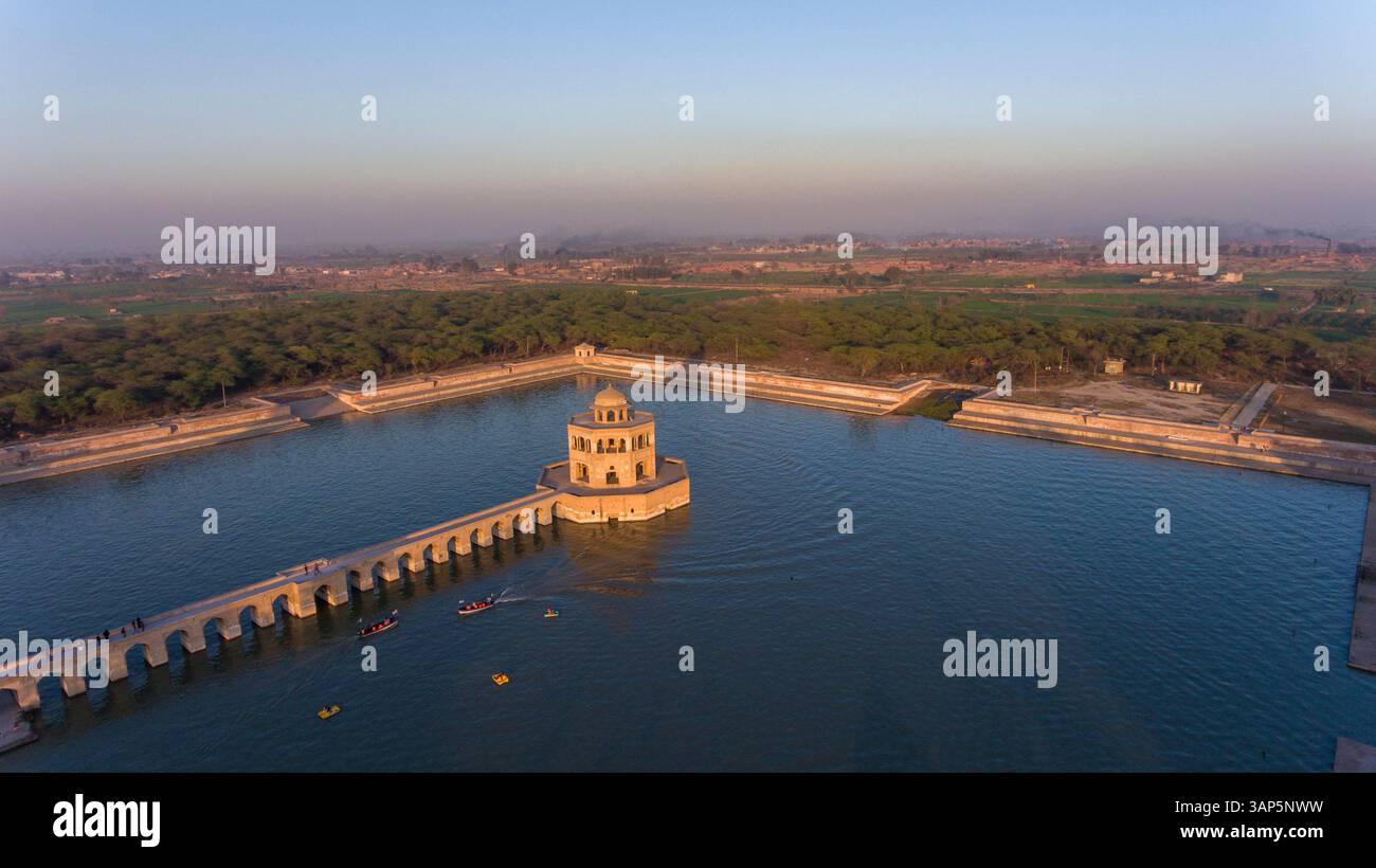 Aerial view of Hiran Minar with serene water reflection and tranquil ...