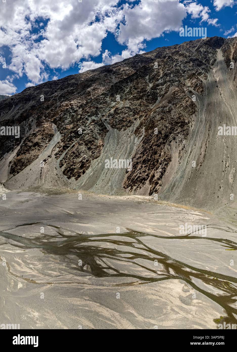 Aerial view of Sadpara Lake surrounded by rugged mountains and dramatic ...